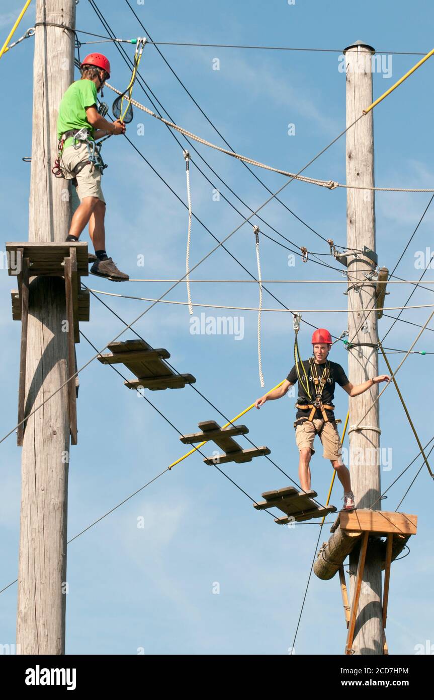 Young man has fun while absolving an balance exercise in high ropes ...