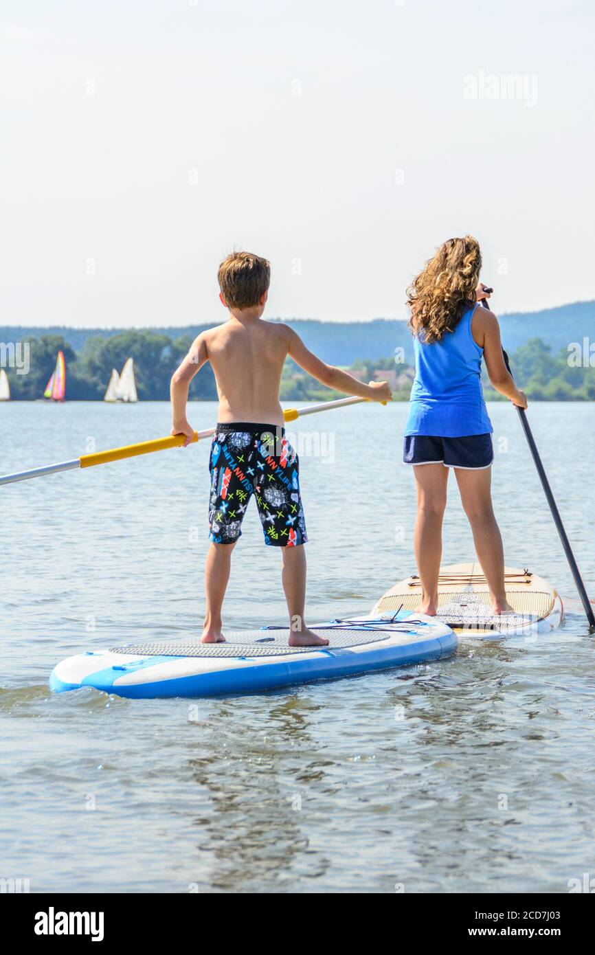 Kids doing Stand up Paddling on lake Stock Photo - Alamy