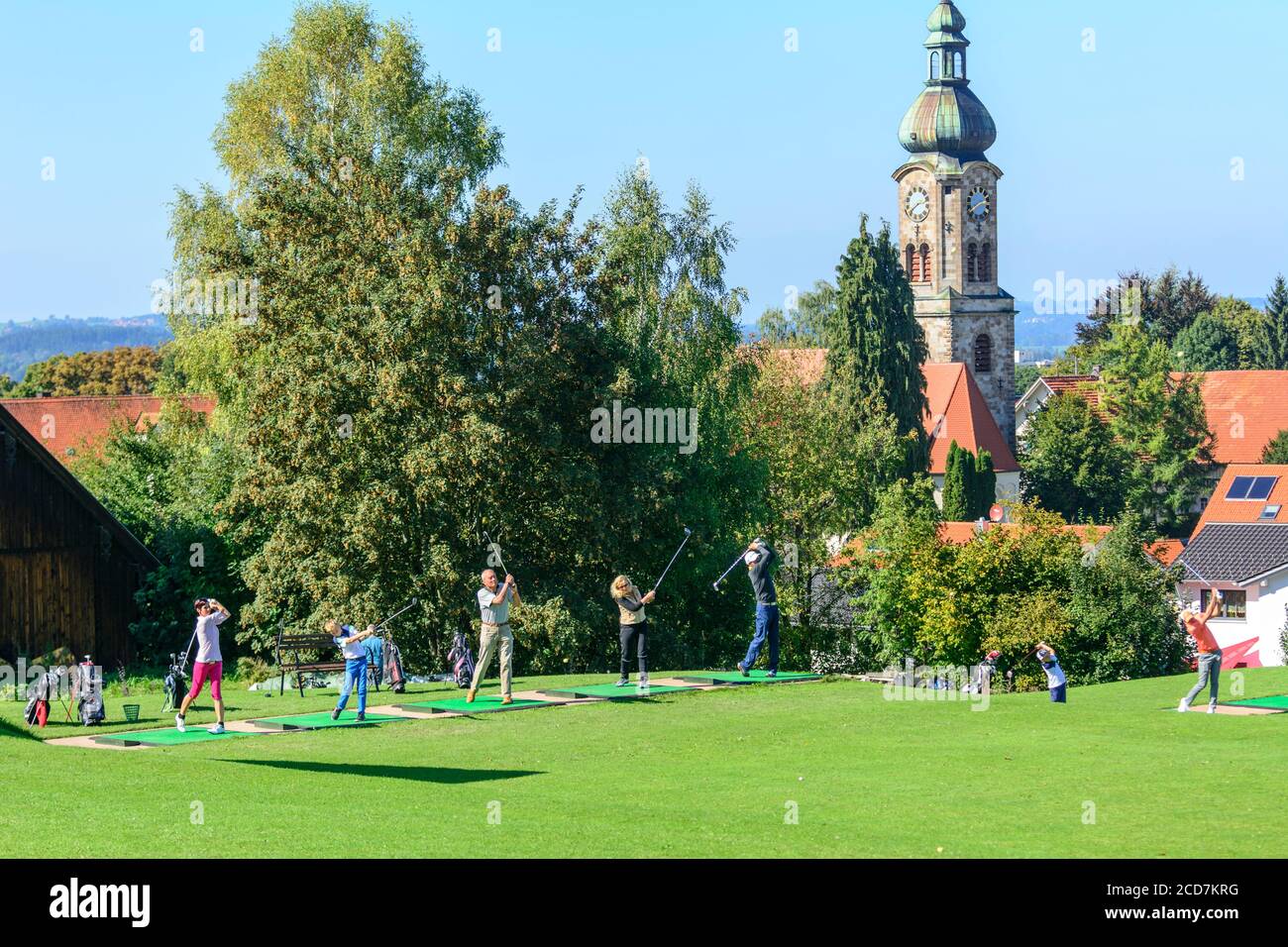 Golf players on driving range Stock Photo - Alamy