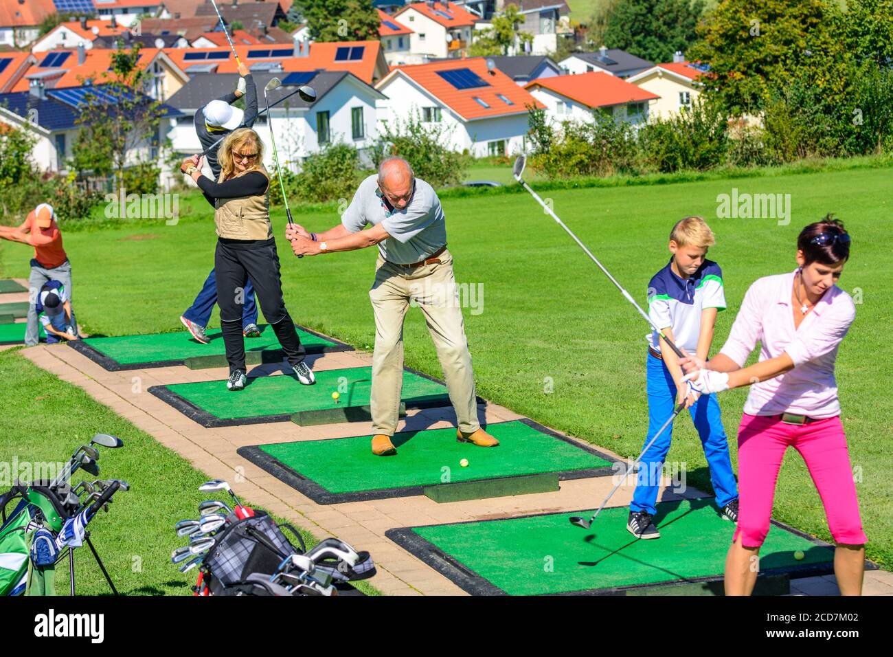 Golf players on driving range Stock Photo - Alamy