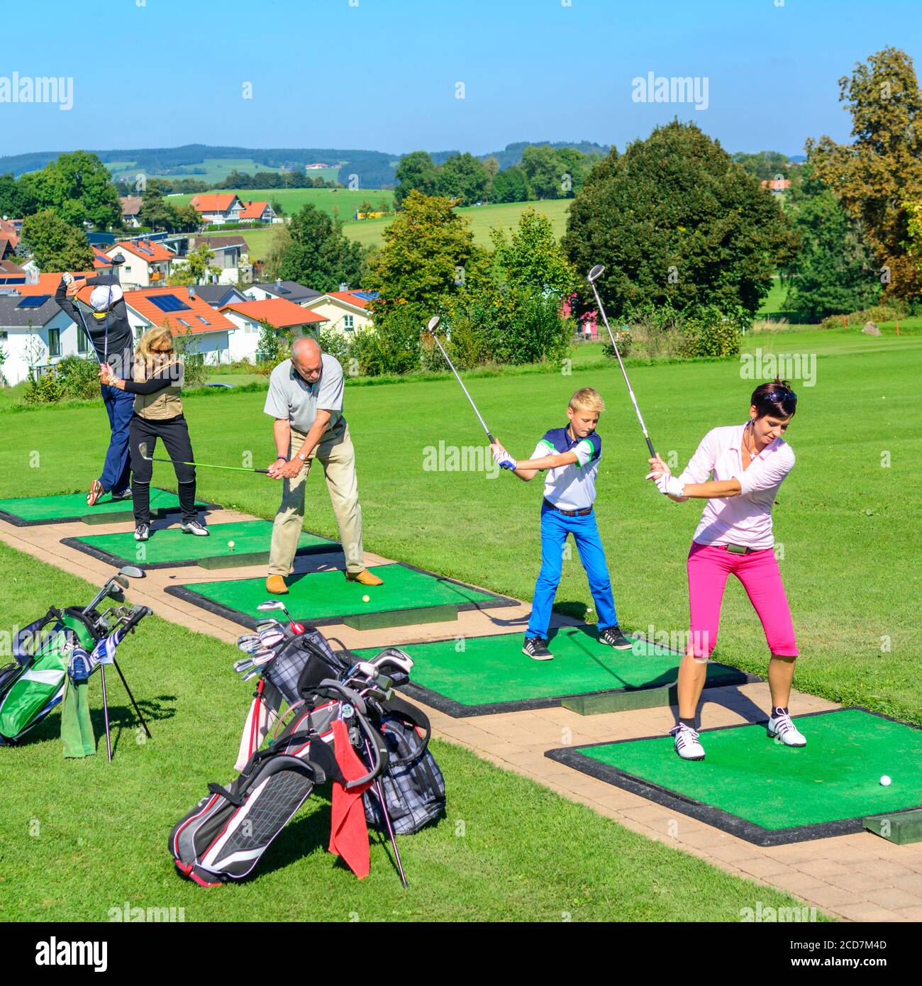 Golf players on driving range Stock Photo - Alamy