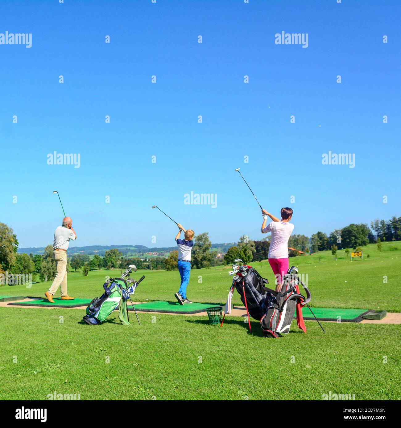 Golf players on driving range Stock Photo - Alamy