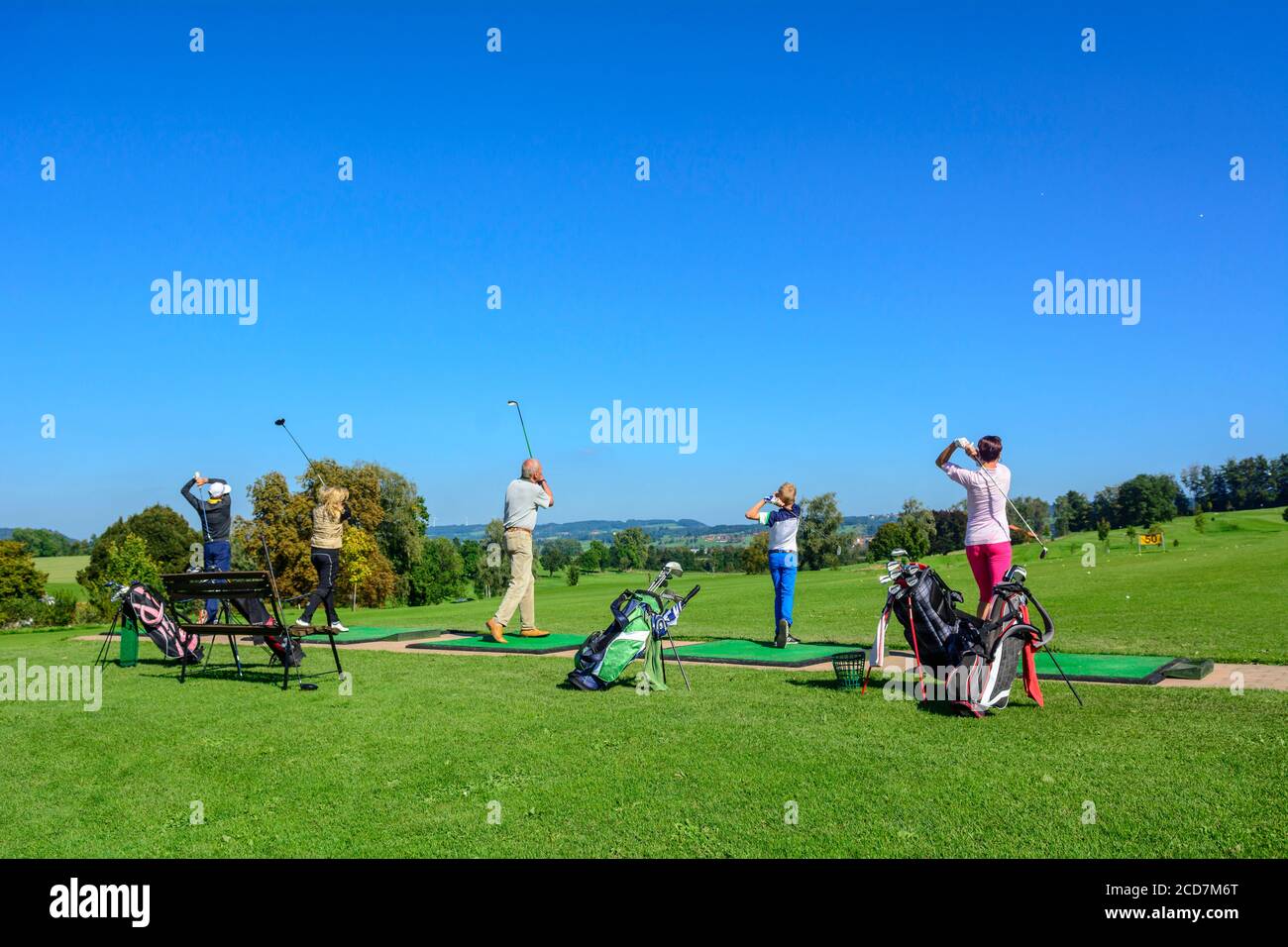 Golf players on driving range Stock Photo - Alamy