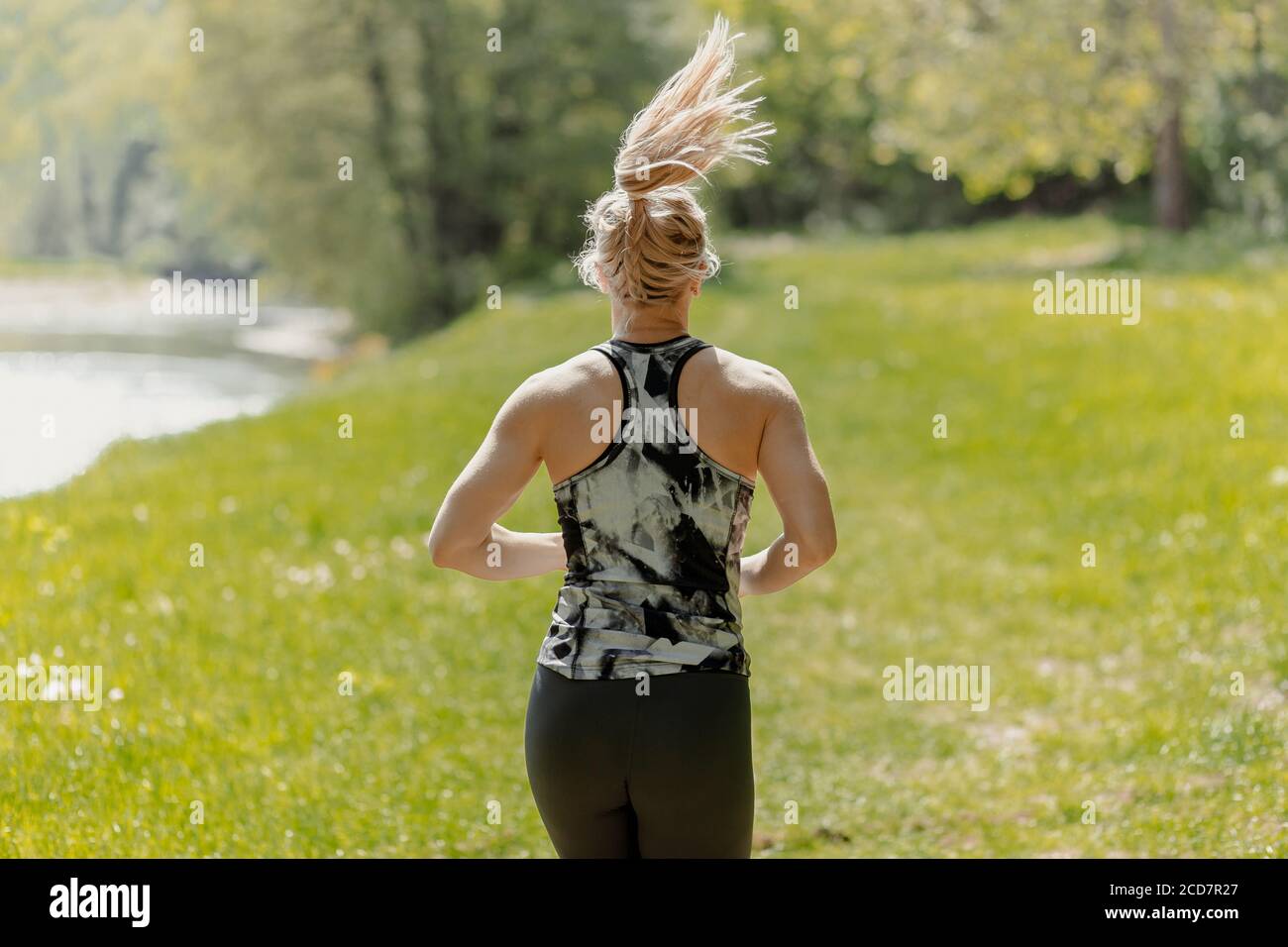 Back view photo of young blonde girl wearing sportswear running in the ...
