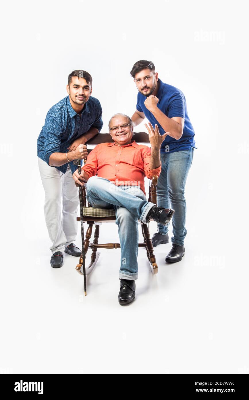 Indian old man or father with young son and daughter, sitting over ...