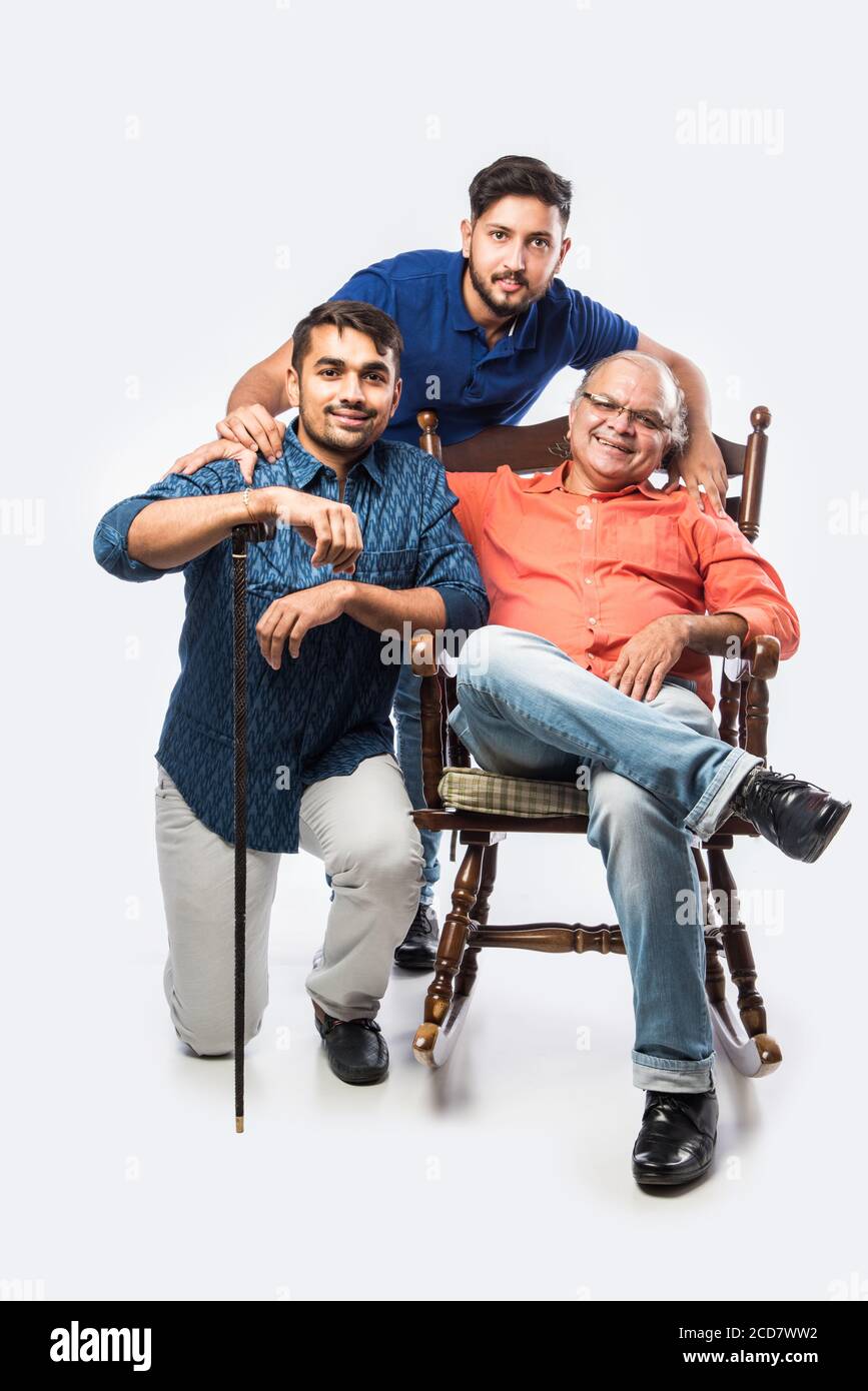 Indian old man or father with young son and daughter, sitting over ...