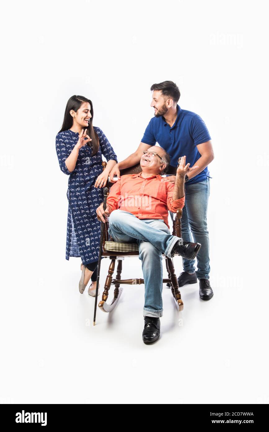 Indian old man or father with young son and daughter, sitting over ...