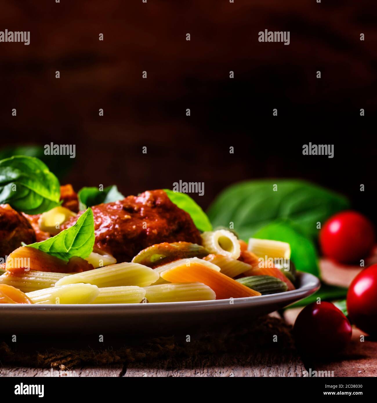 Colorful penne pasta with meatballs in tomato sauce with basil, vintage ...