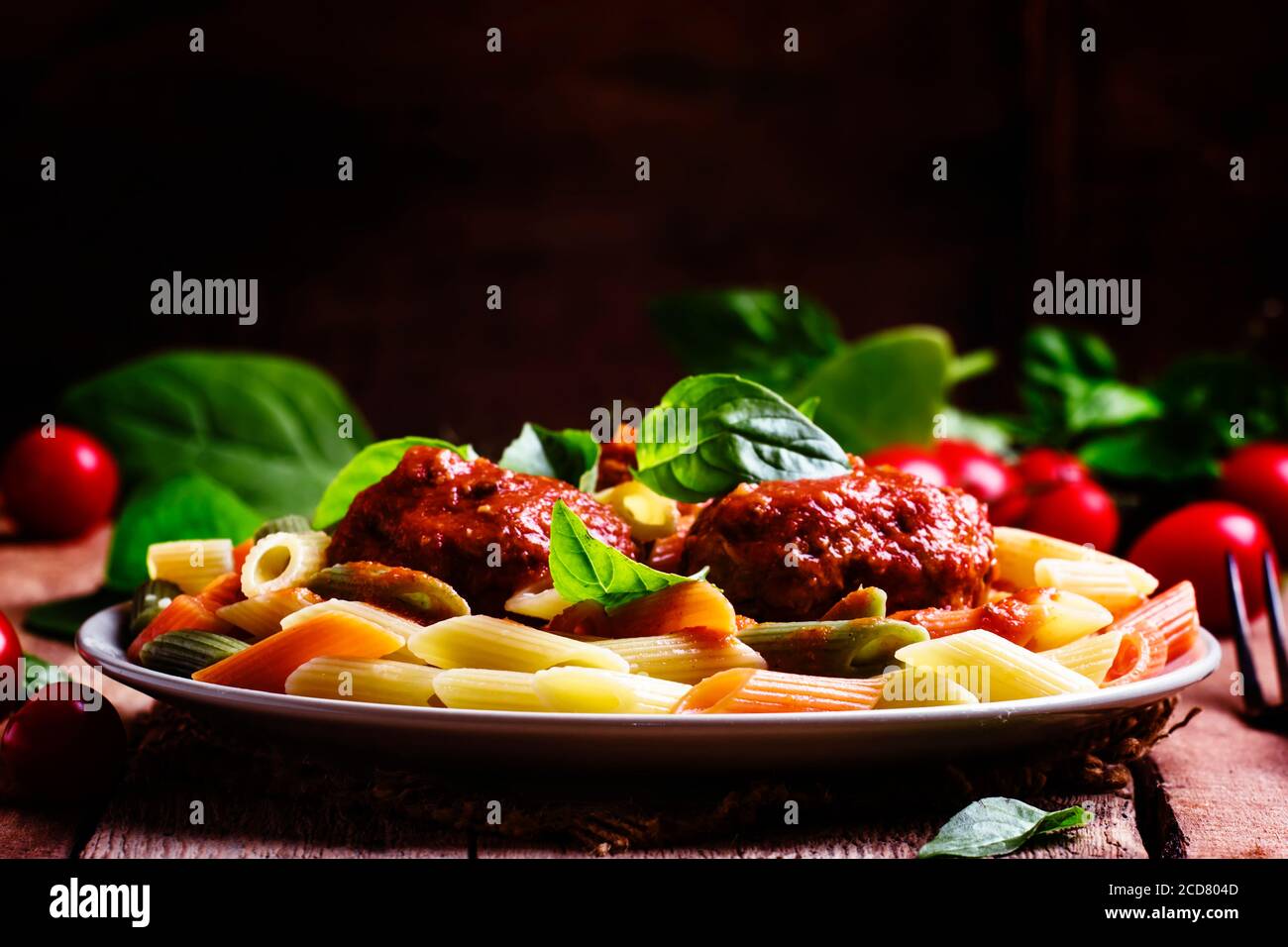 Colorful penne pasta with meatballs in tomato sauce with basil, vintage ...