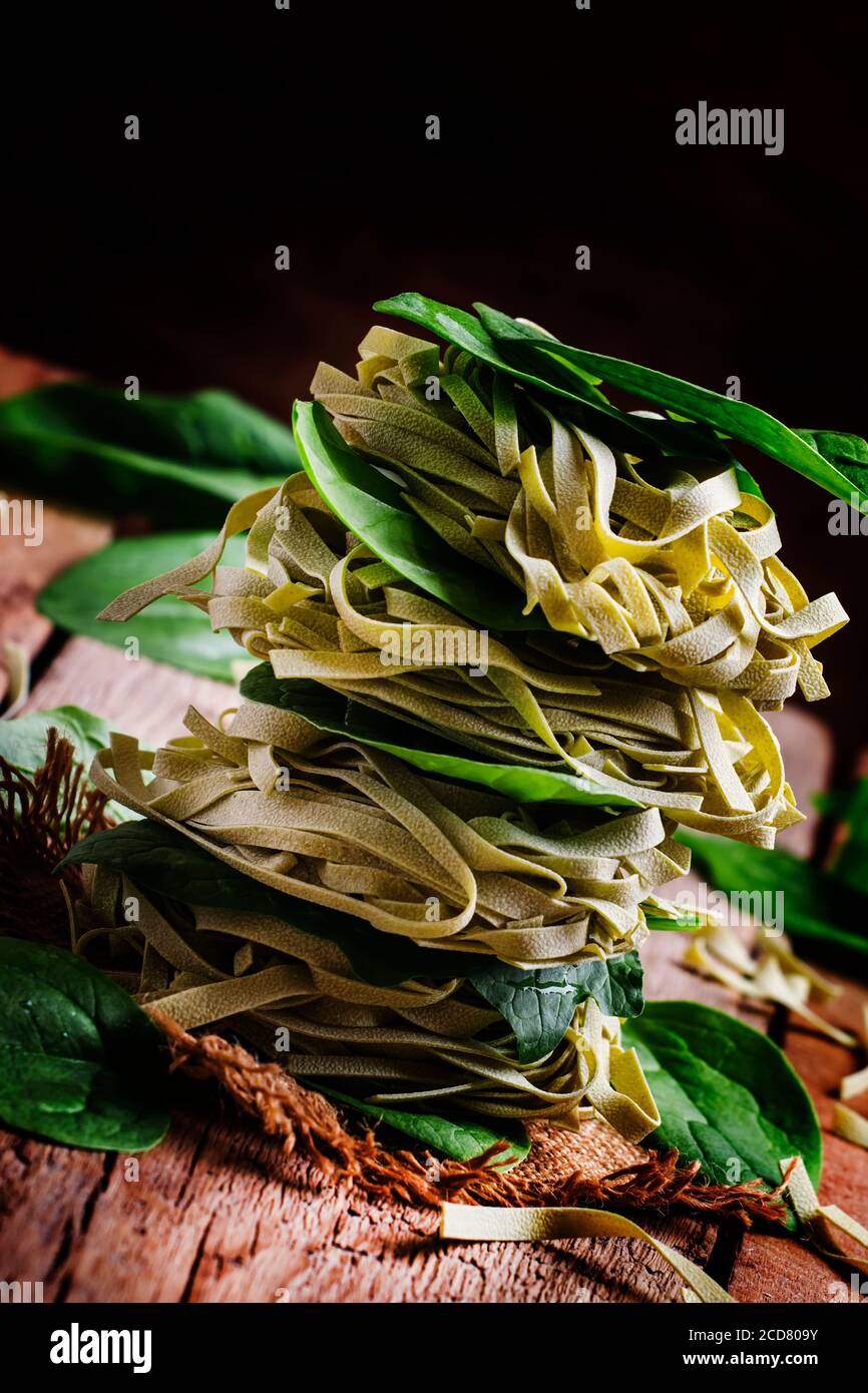 Dry spinach pasta with green leaves, folded like a tower, vintage ...