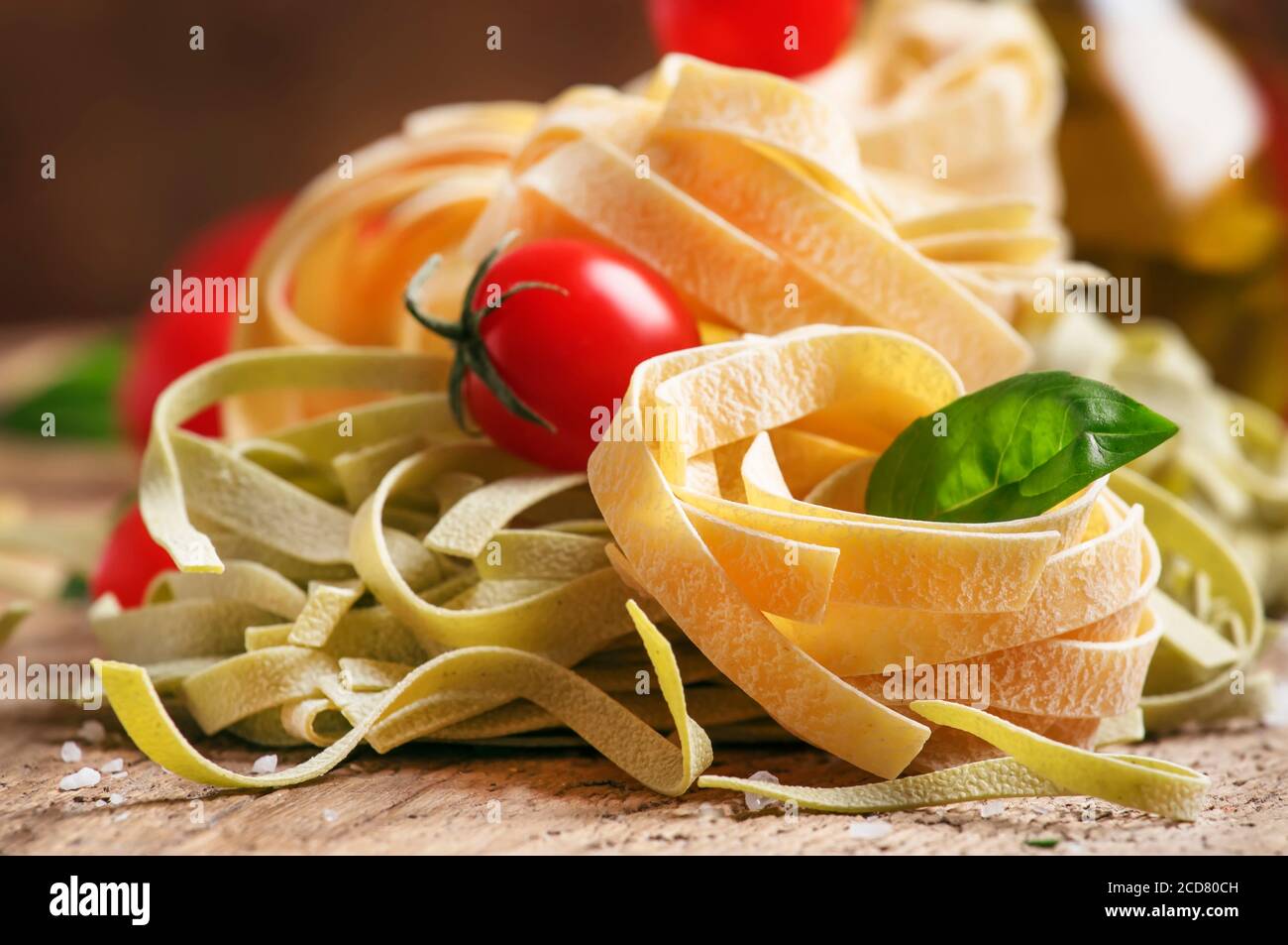 Concept of italian food cooking with green and yellow tagliatelle pasta ...