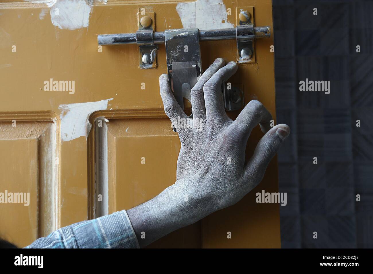 worker labour dirty hand holding steel aldrop door lock on brown door ...