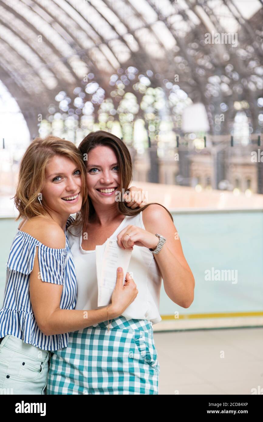 Young girls holding train tickets and cuddling Stock Photo - Alamy