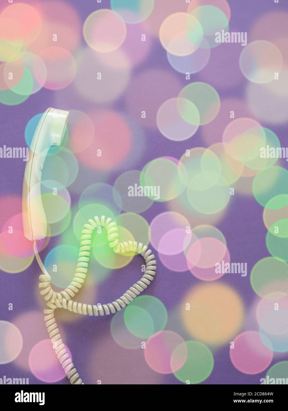 Telephone handset with heart on purple background Stock Photo - Alamy