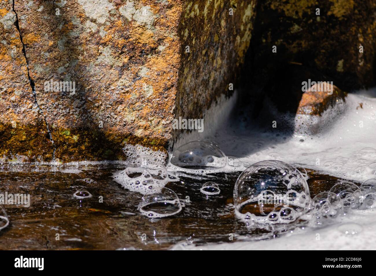 Bubbles floating down stream in this peavul scene with textured rocks ...