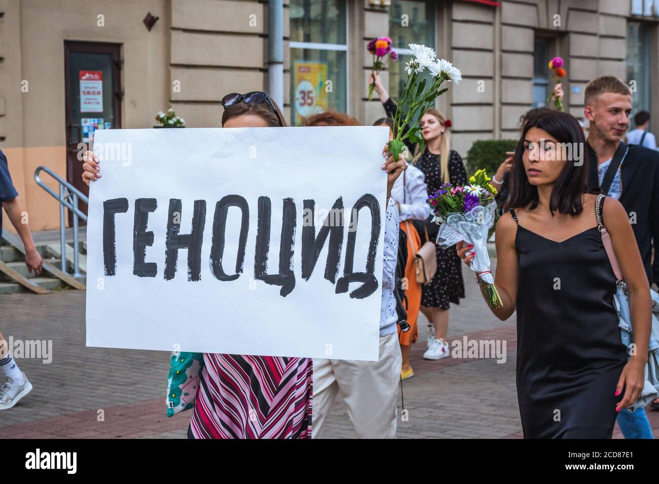 Woman holding sign in russian "genocide" during peaceful protests ...