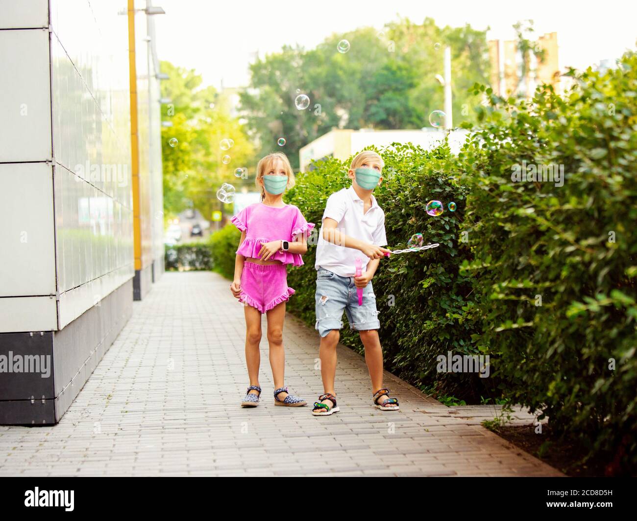 Happy little kids wearing protective face mask jumping and running on ...