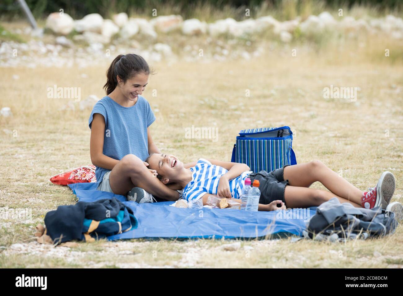Two sisters talking and laughing on the mountain and the youngest one ...