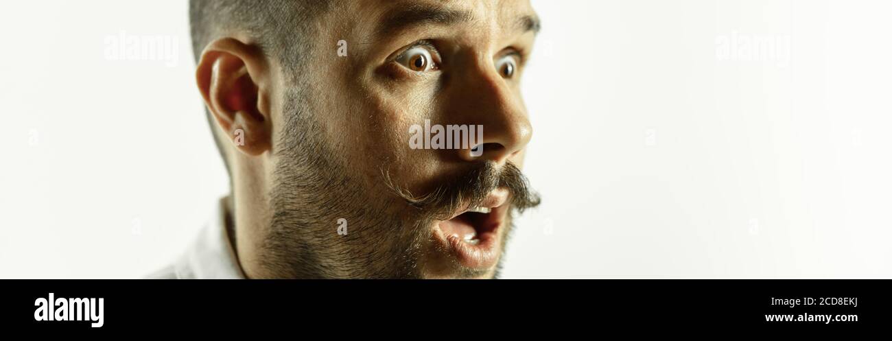 Shocked, astonished. Caucasian young man's close up cropped shot on ...