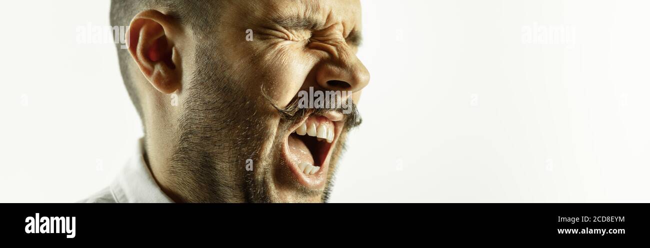 Screaming. Caucasian young man's close up cropped shot on studio ...