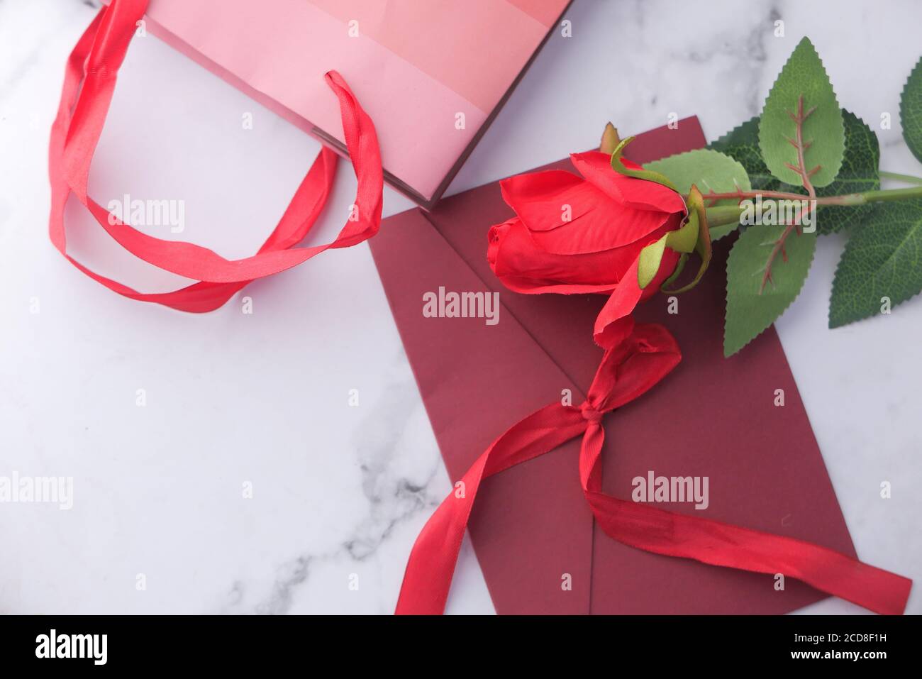 Top view of gift box, envelope and rose flower on white background ...