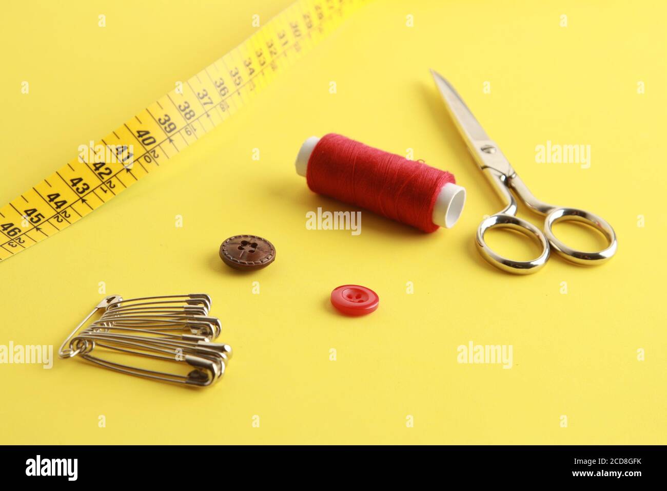 Sewing items on a yellow surface Stock Photo - Alamy