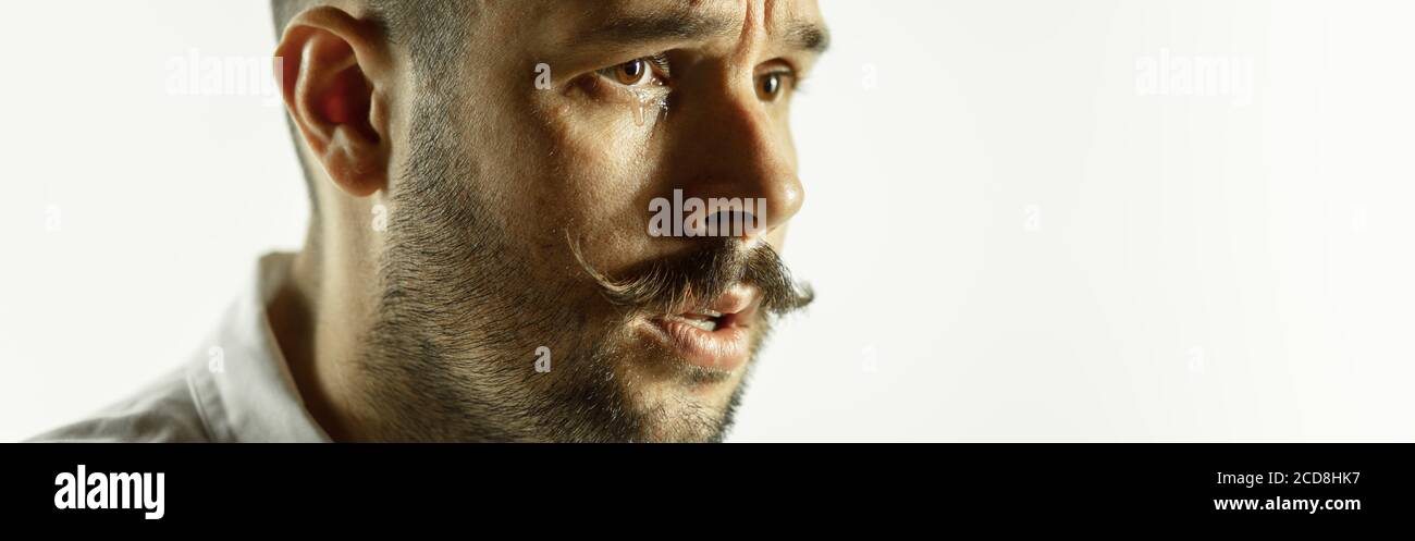 Crying. Caucasian young man's close up cropped shot on studio ...