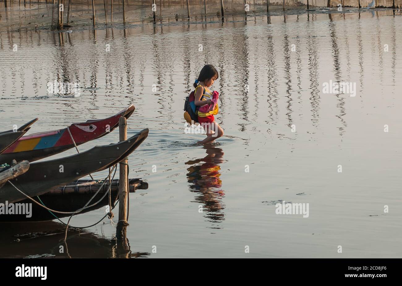 Little girl, wading to school, in Tam Giang lagoon, Hue, Vietnam Stock ...