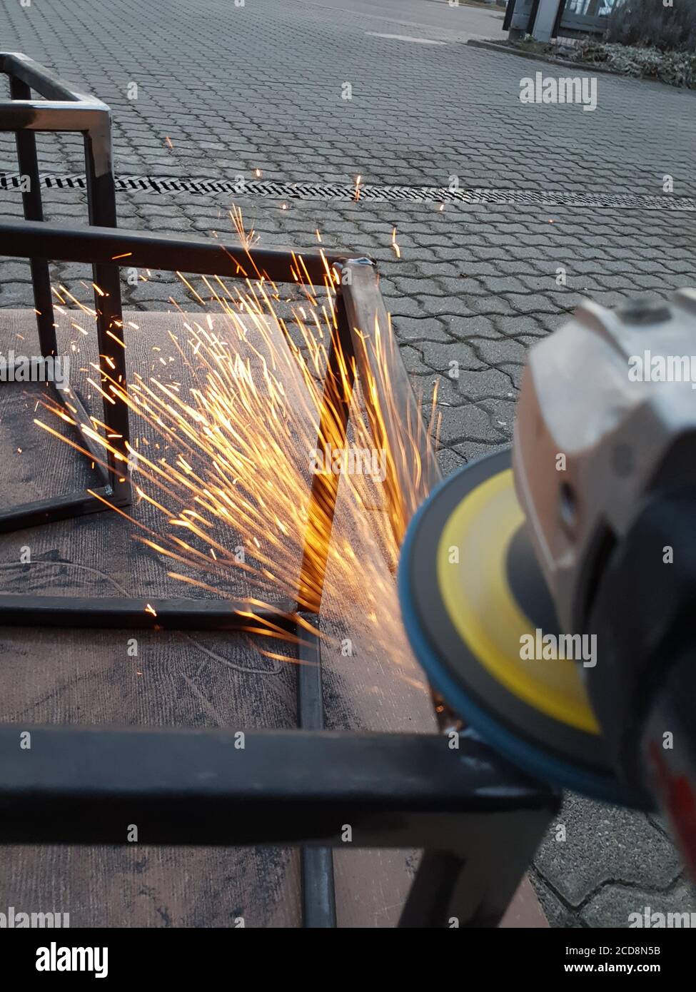 Vertical shot of a worker grinds the metal with angular grinding ...