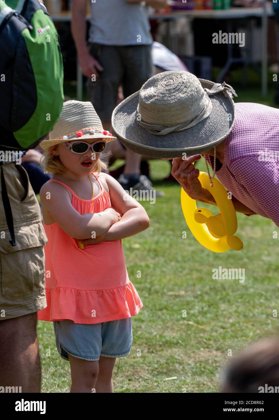 Small child looking grumpy on a day out Stock Photo - Alamy