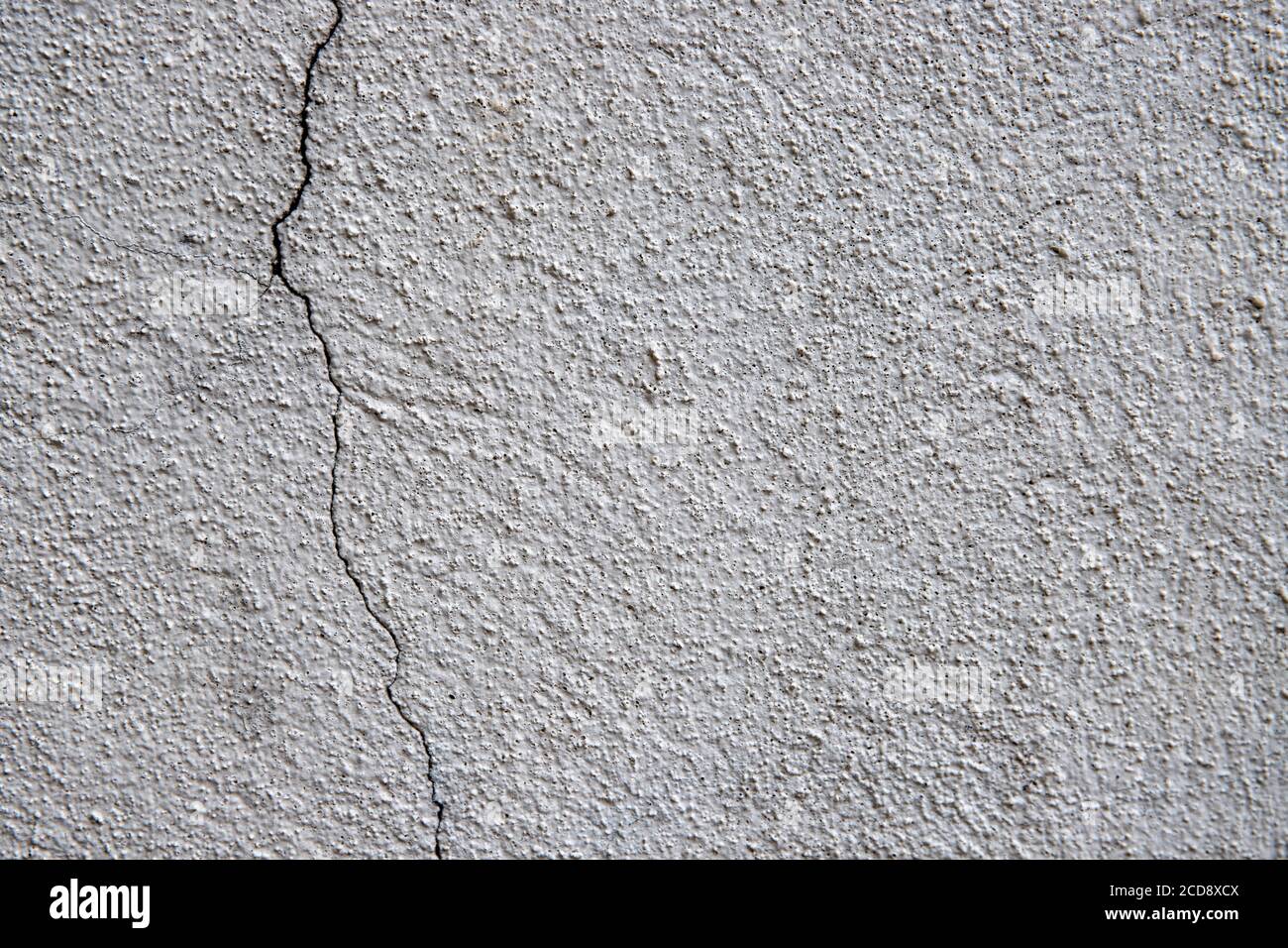 Pale plaster painted wall with grit and cracks. Cracked wall closeup ...