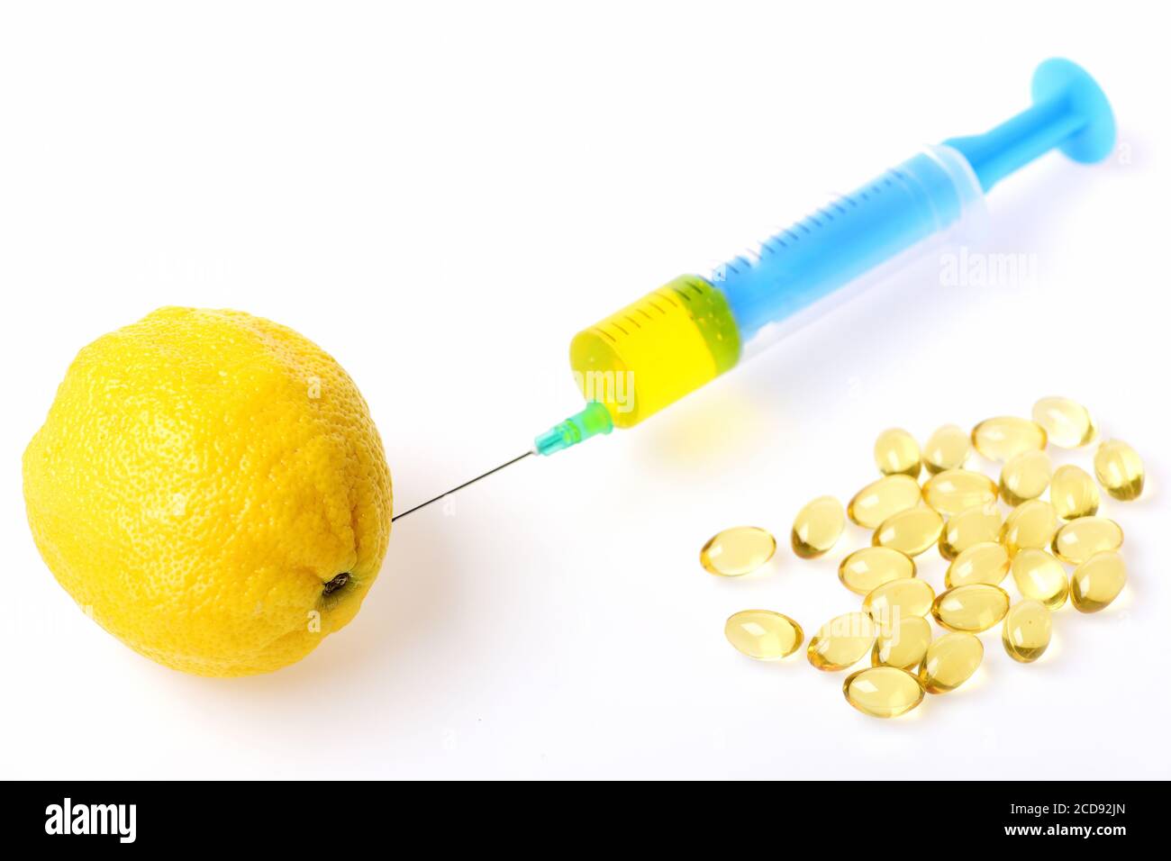 Syringe in lemon and fish fat capsules. Syringe, capsules and fresh ...