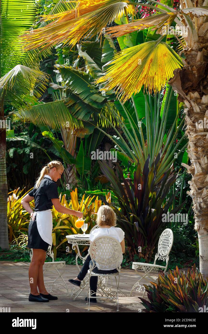 Spain, Canary Islands, La Palma, waitress serving a glass of orange ...