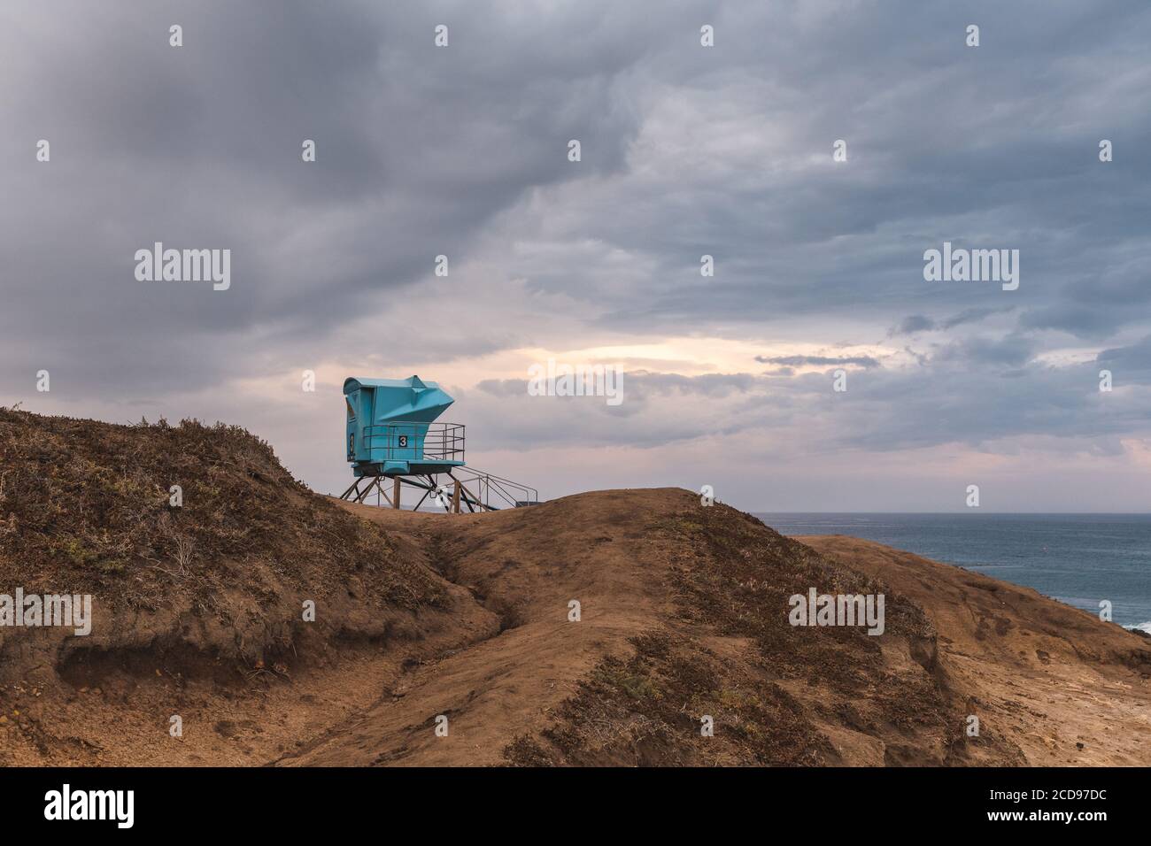 Blue watchtower on a hill near the beach under cloudy beautiful sky in ...
