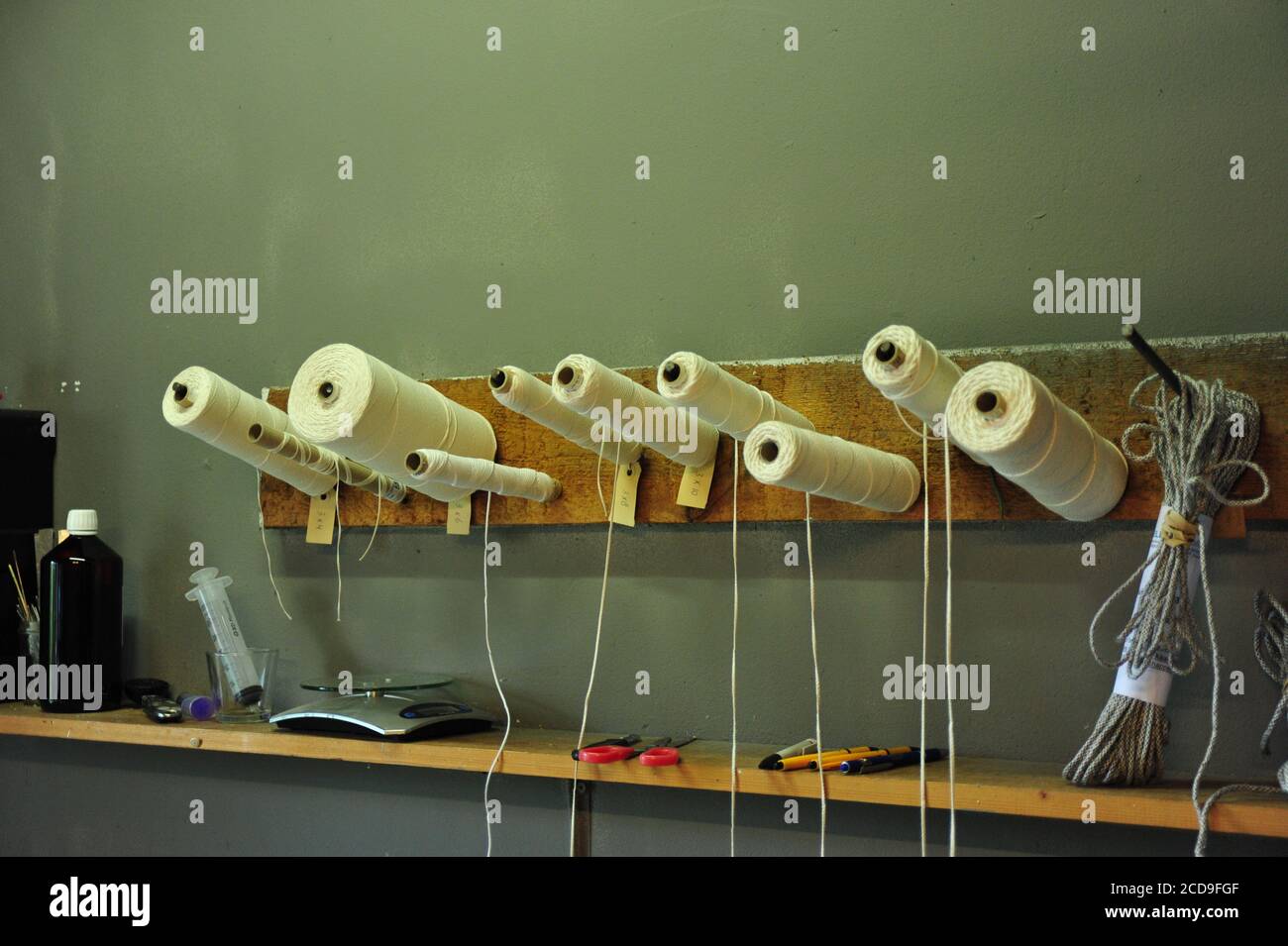 Line of thread rolls hanging on a sewing equipment Stock Photo - Alamy