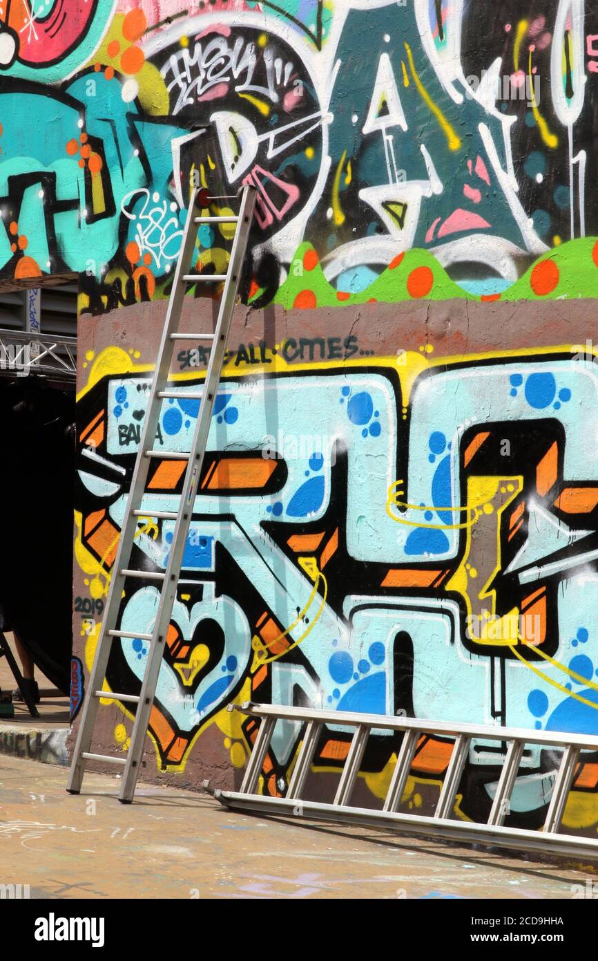 The ladder is leaning against the wall with graffiti Stock Photo - Alamy
