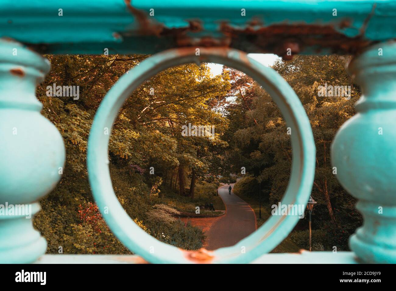 Frame in a frame shot of a pathway at a park as seen through decorative ...