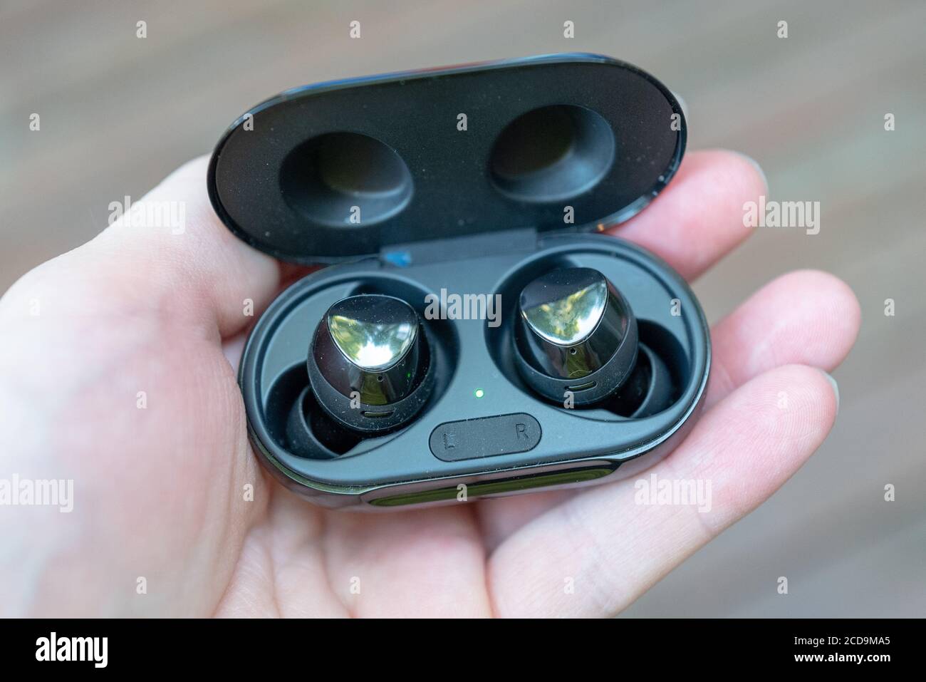 Close-up of hand of a man holding Samsung Galaxy Buds wireless ...