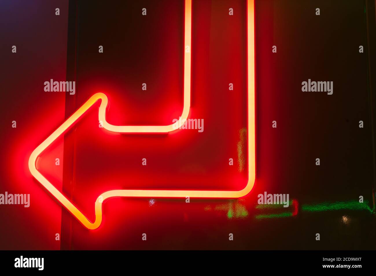 Red neon arrow sign on dark background.at night Stock Photo - Alamy