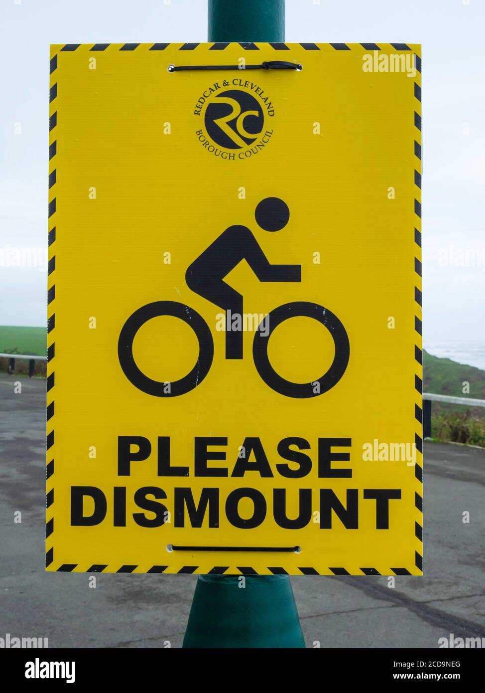 A Cyclists Please Dismount sign on the cliff top promenade at Saltburn ...