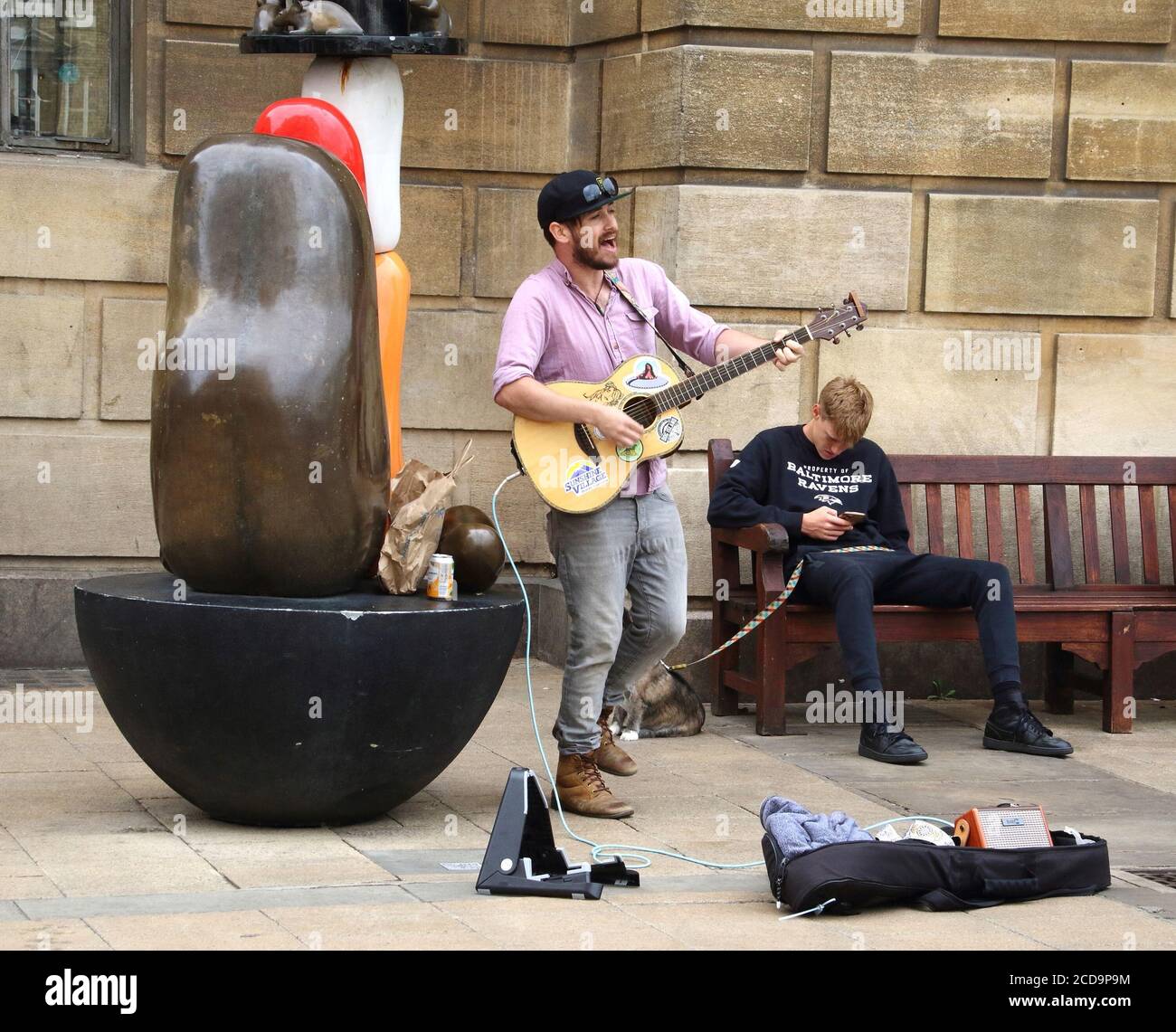 Cambridge, UK. 26th Aug, 2020. A busker singing with a guitar in the ...