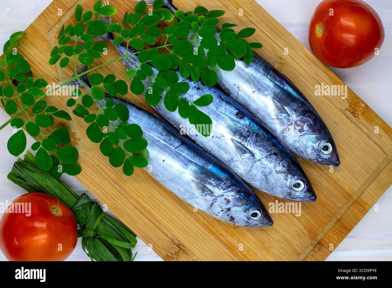 Fresh sea sardine and greenery on white wooden background, sea food ...