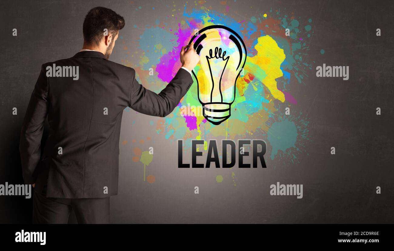 businessman drawing colorful light bulb with LEADER inscription on ...