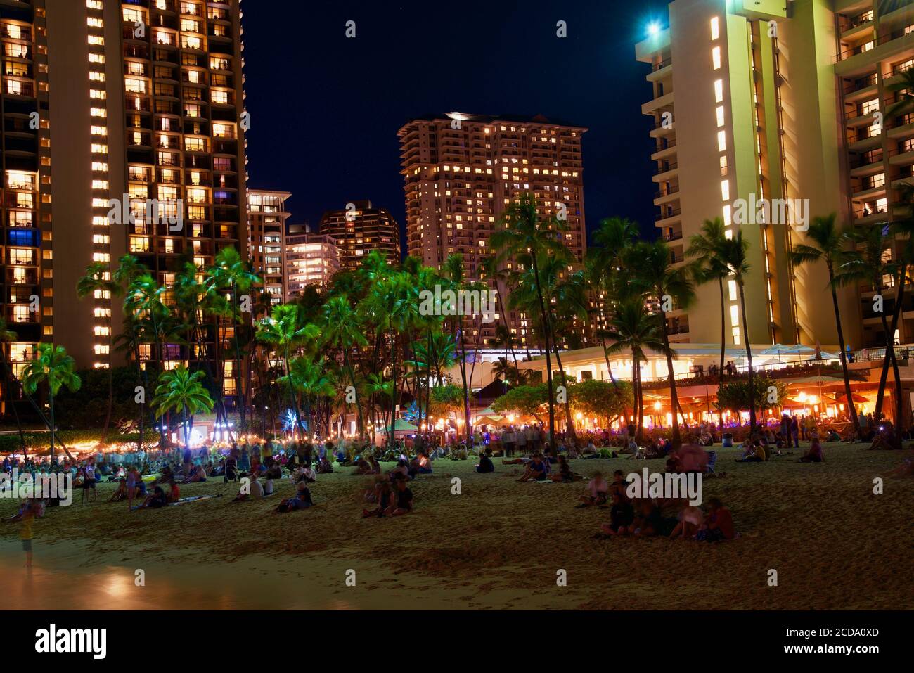 Crowds gathered to watch firework display over touristy beach, in front ...