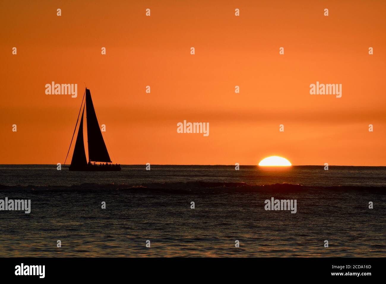 Spectacular and colorful golden sunset with silhouetted sailboat and ...