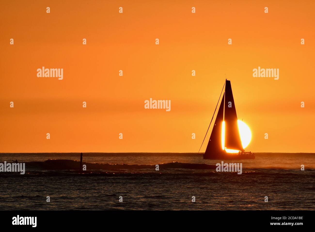 Spectacular and colorful golden sunset with silhouetted sailboat and ...