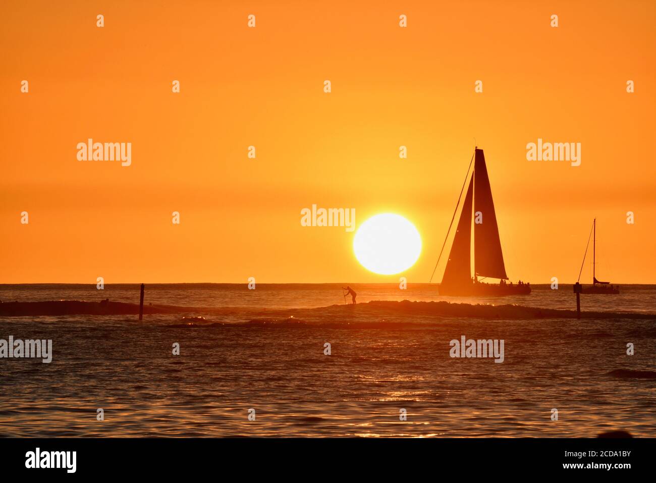 Spectacular and colorful golden sunset with silhouetted sailboat and ...