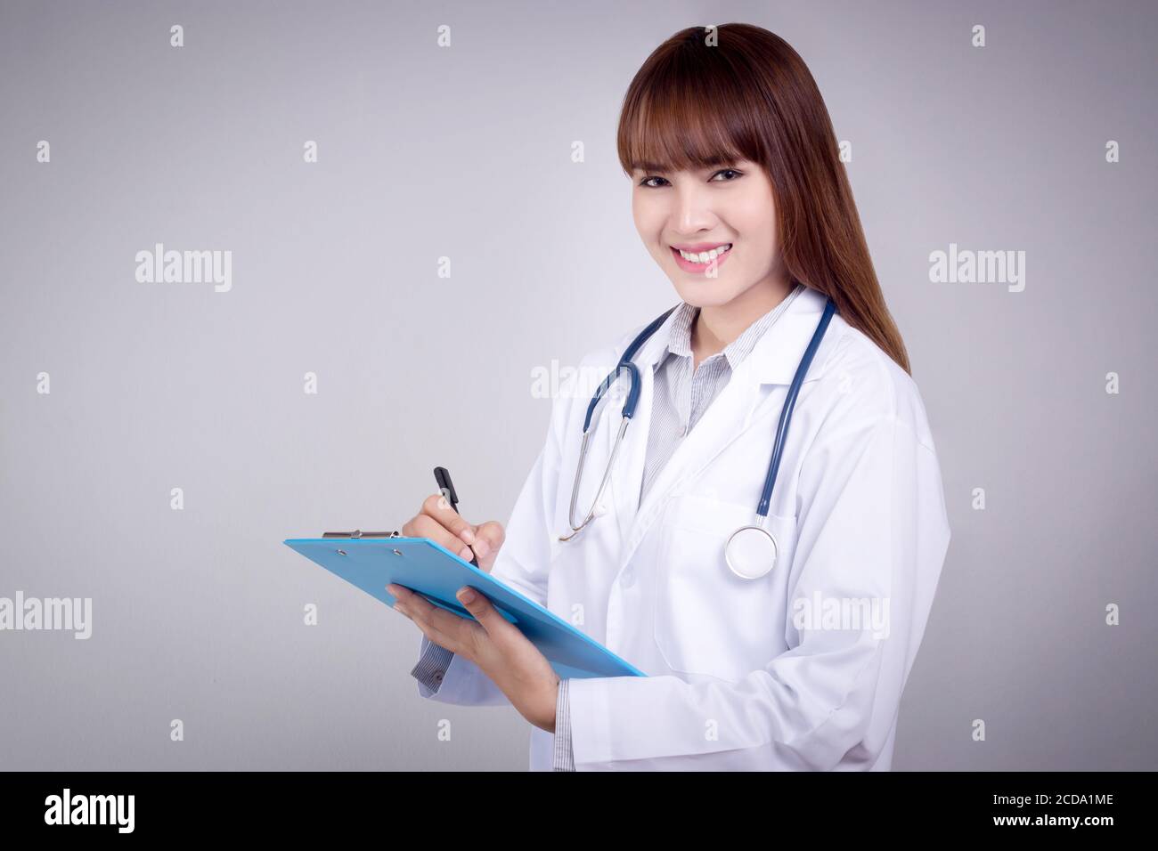 Healthy concept : Young Asian doctor writing on clipboard for patient ...