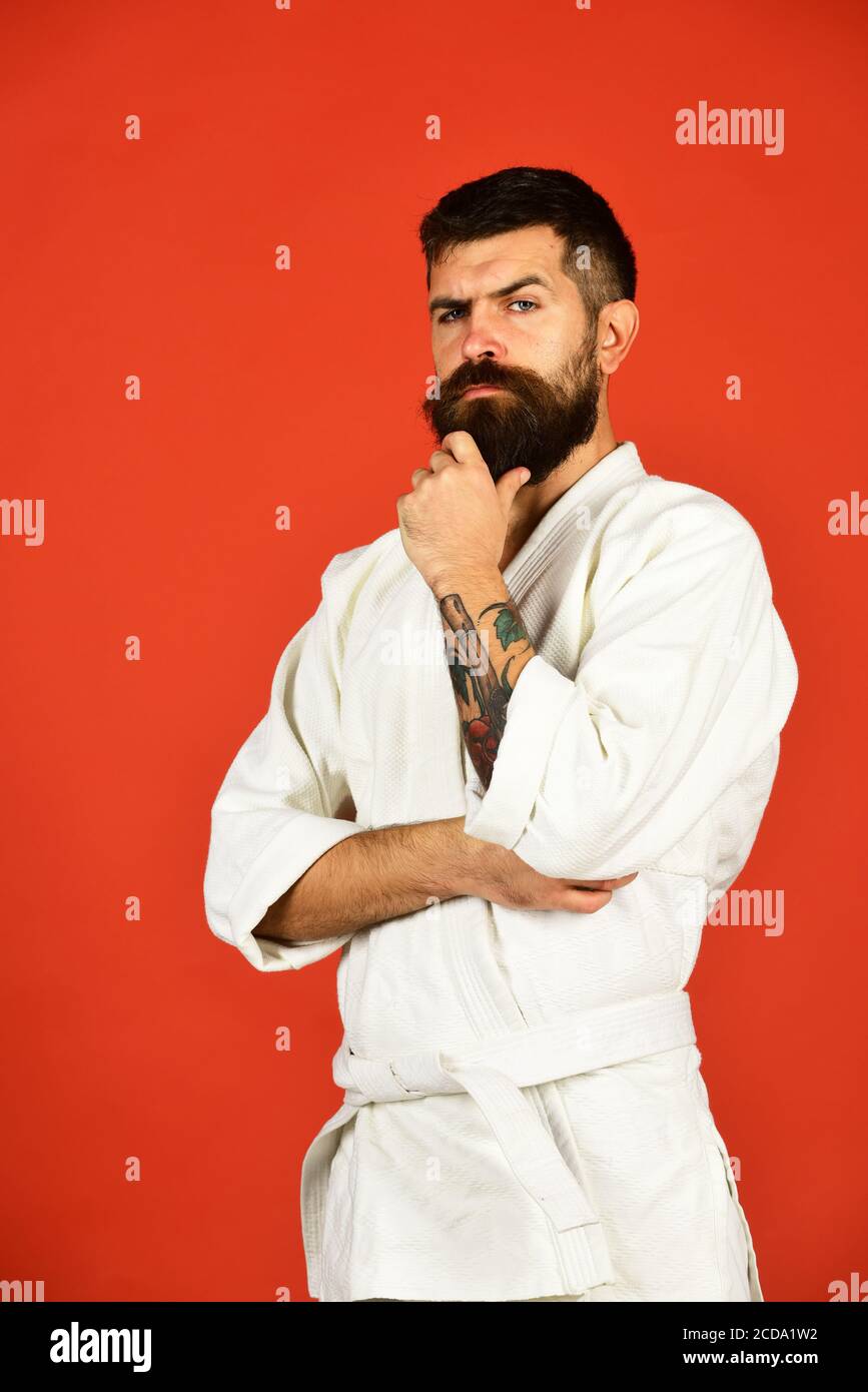 Jiu Jitsu master rubs his beard and thinks. Man with beard in white ...