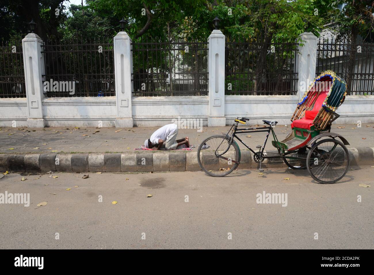 A Bangladeshi Muslim Rickshaw driver offer prayer on the street in ...